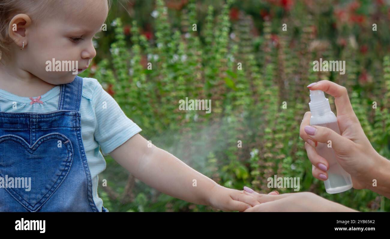 mother applies an aerosol insect spray to the child's body. Selective ...