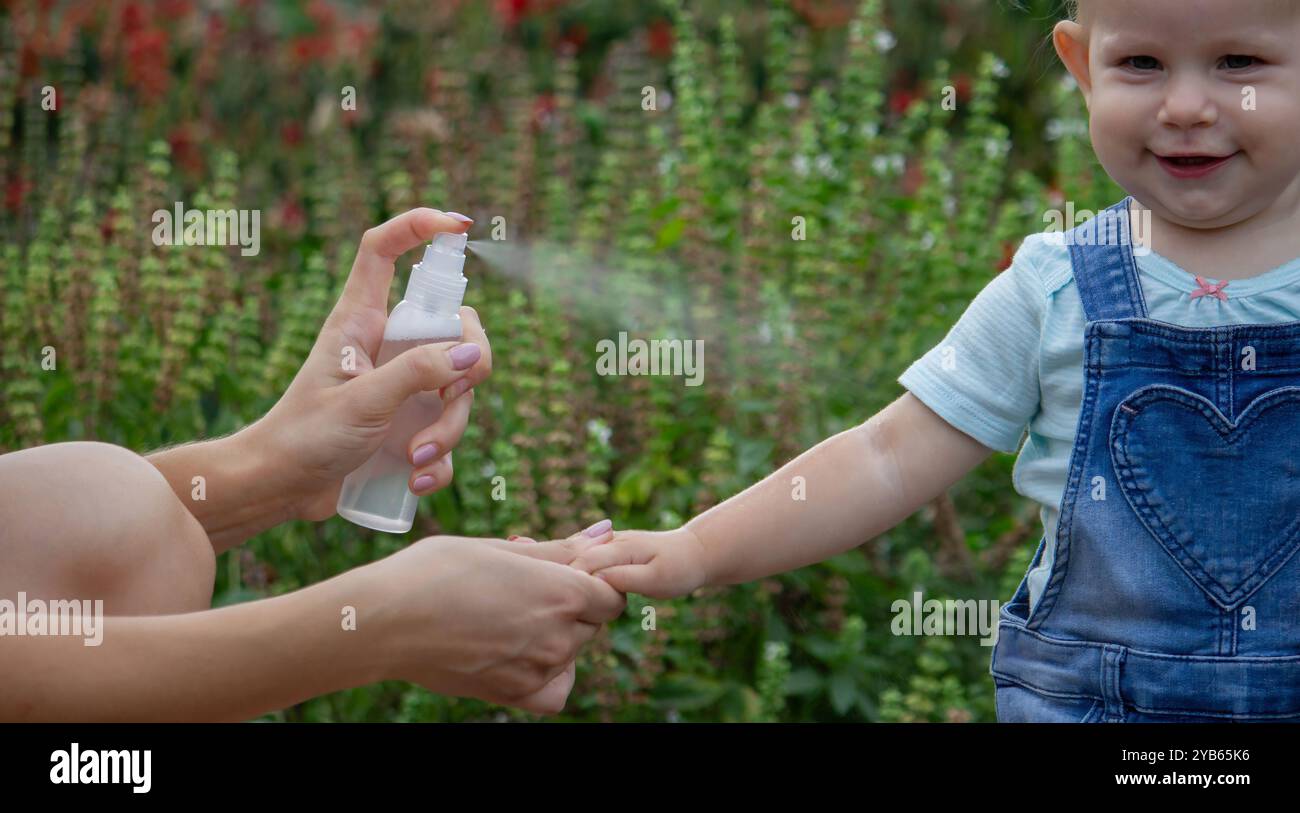 mother applies an aerosol insect spray to the child's body. Selective ...