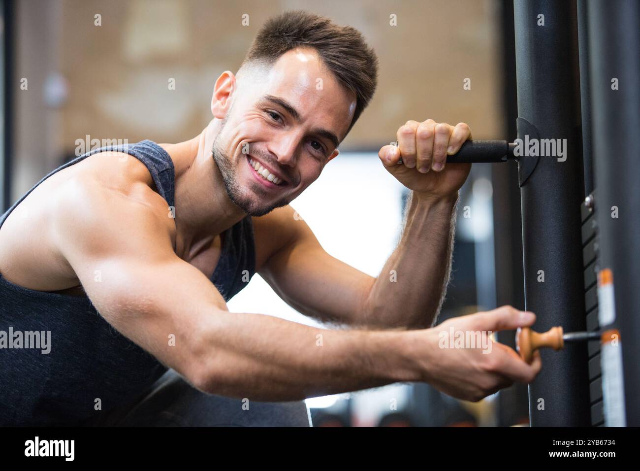 happy man adding weight to a chest pectoral machine Stock Photo - Alamy