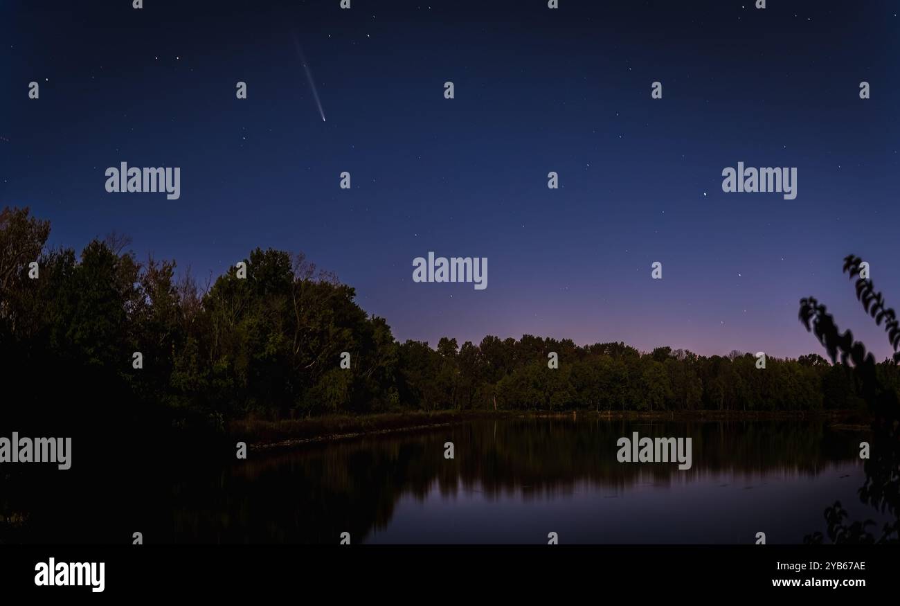 Vertical Vew of comet over Midwestern lake; woods around the lake; full ...