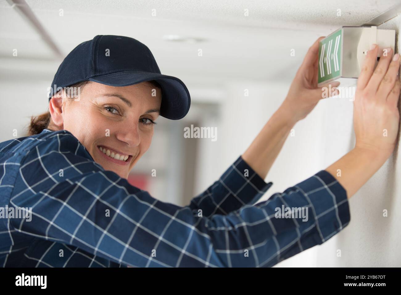 woman standing under exit sign Stock Photo - Alamy