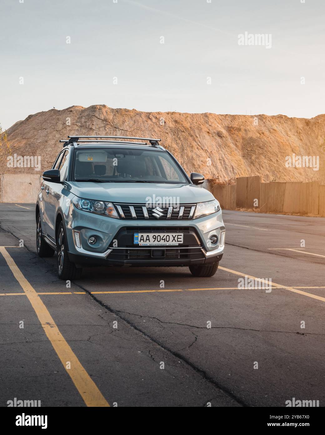 blue Suzuki Vitara in parking lot (vertical). Front three quarter view ...