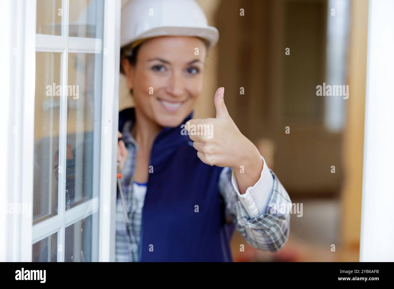 happy female builder showing thumb-up Stock Photo - Alamy