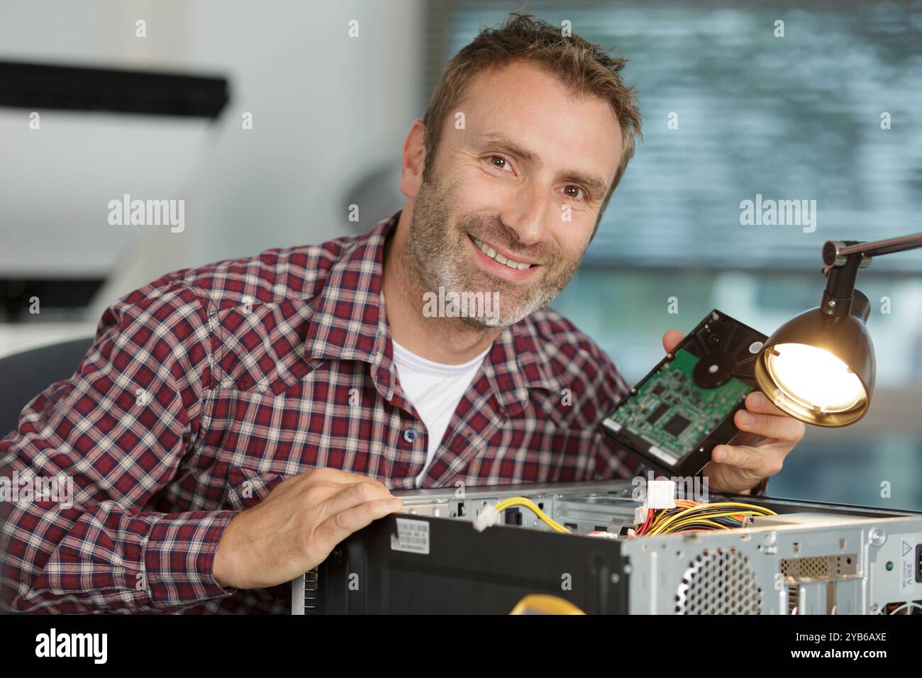 smiling man using multimeter while fixing pc Stock Photo - Alamy