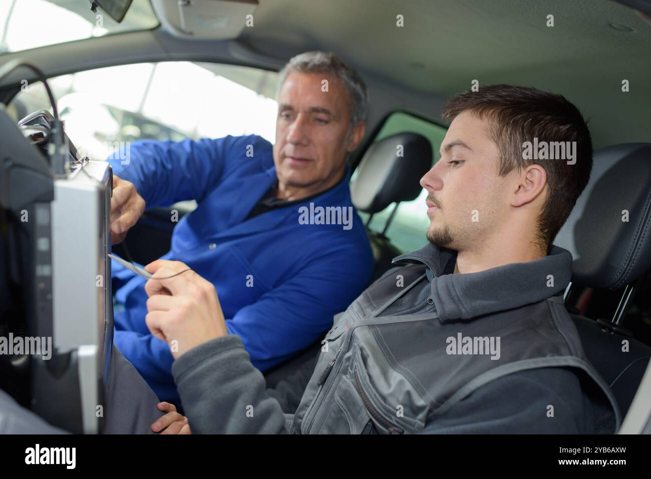 student with instructor repairing a car during apprenticeship Stock ...