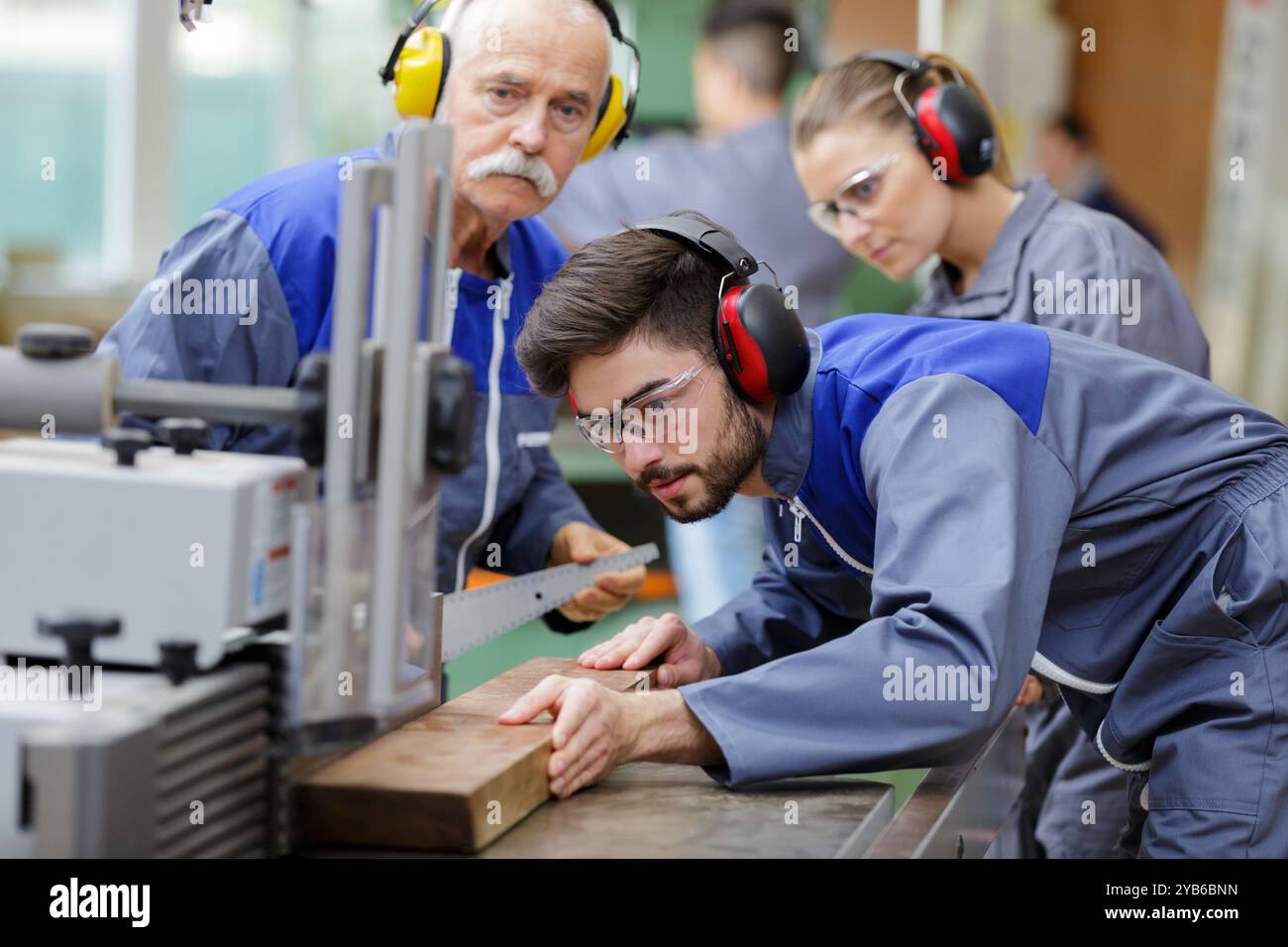 carpenter training apprentice to use plane Stock Photo - Alamy