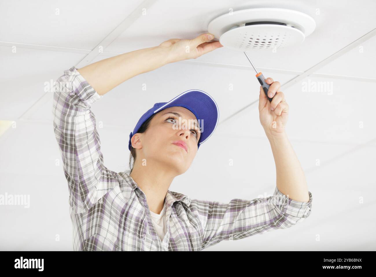 woman pulling to the ceiling in repair Stock Photo - Alamy