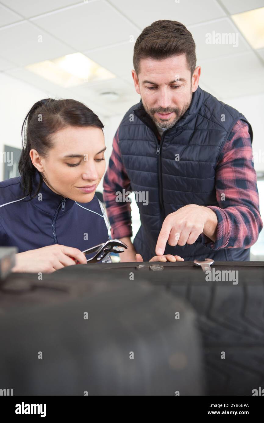 mechanic and female trainee working underneath car together Stock Photo ...
