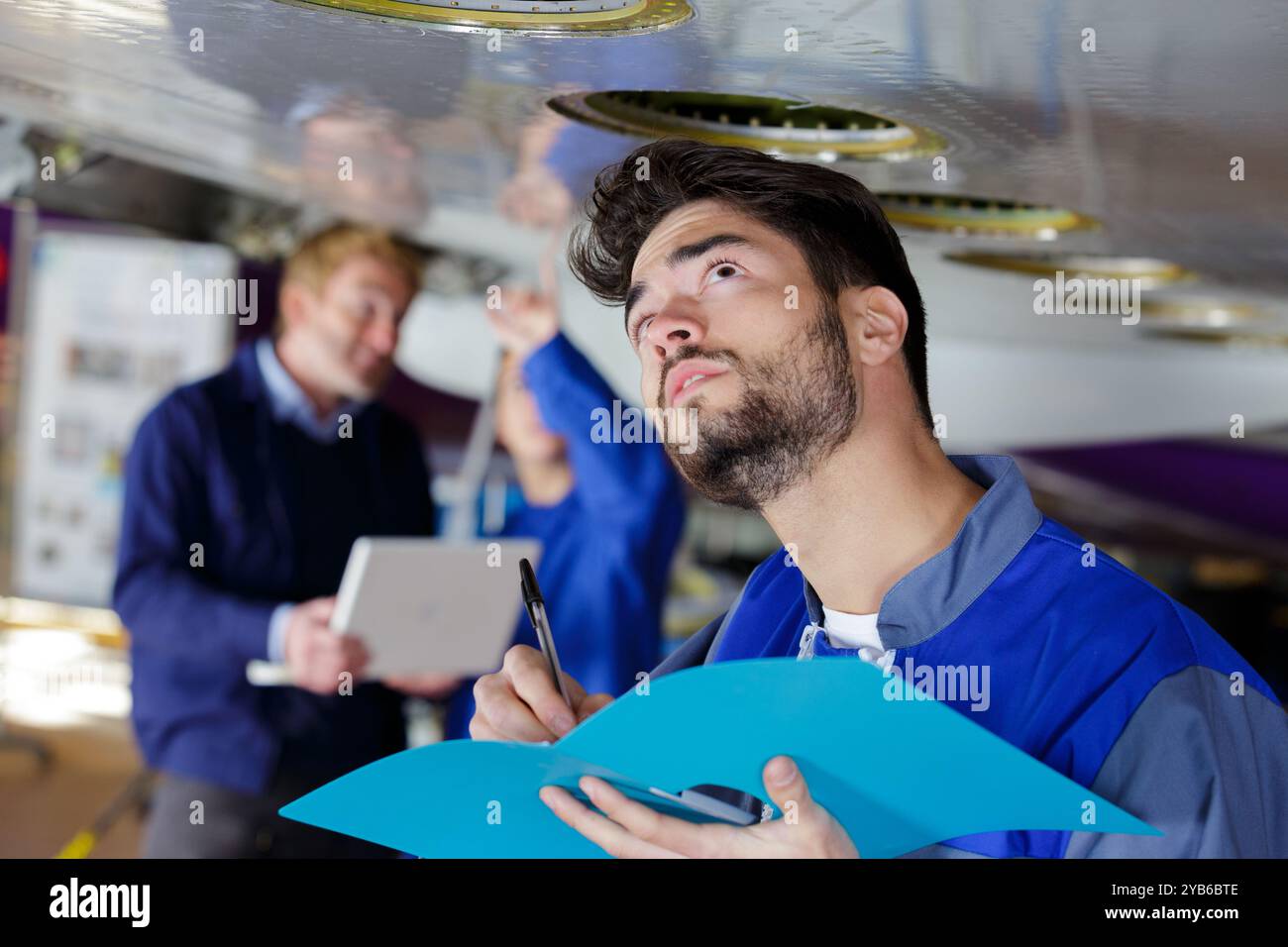 engineer making notes underneath an aircraft Stock Photo - Alamy