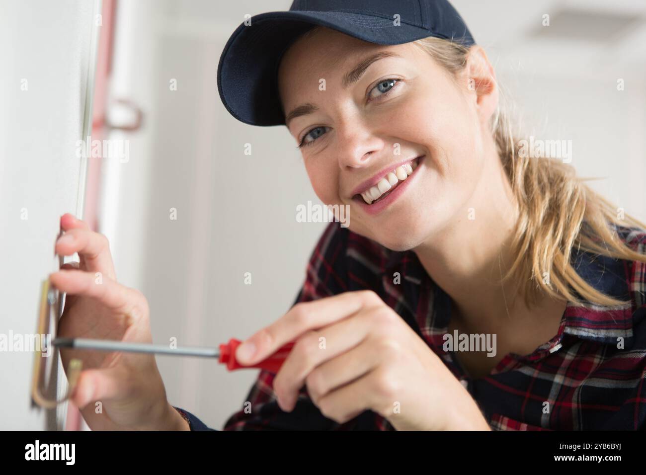 happy female technician is screwing an electric socket Stock Photo - Alamy