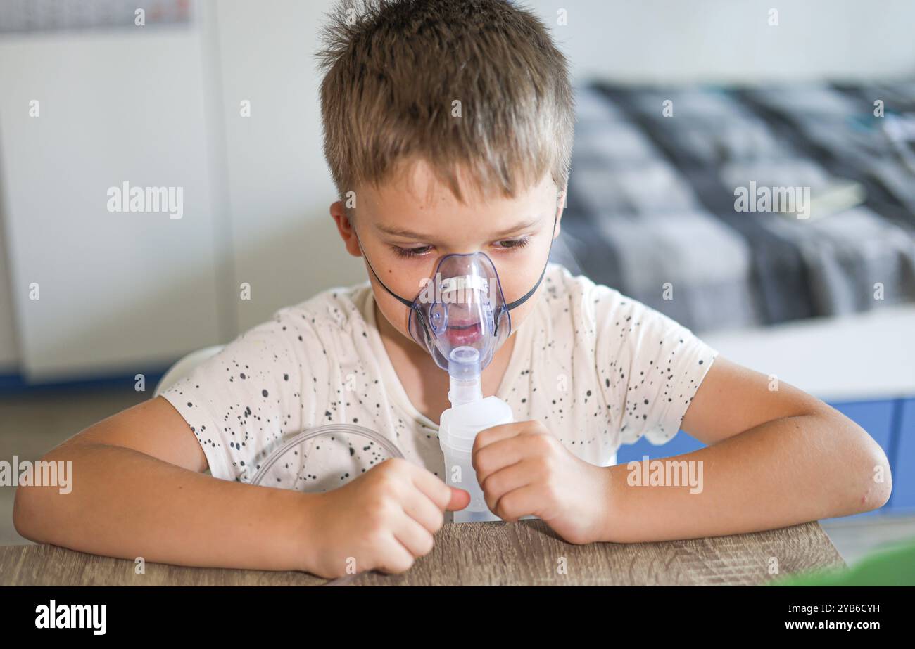 The Caucasian boy makes inhalation with a nebulizer inhaling medicines ...