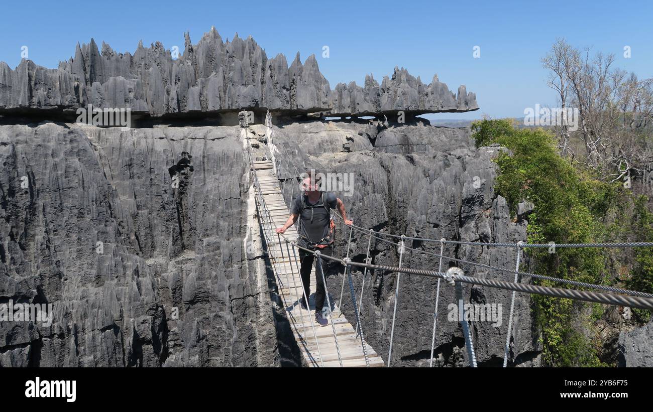 German man walking over suspension bridge in Tsingy de Bemaraha ...