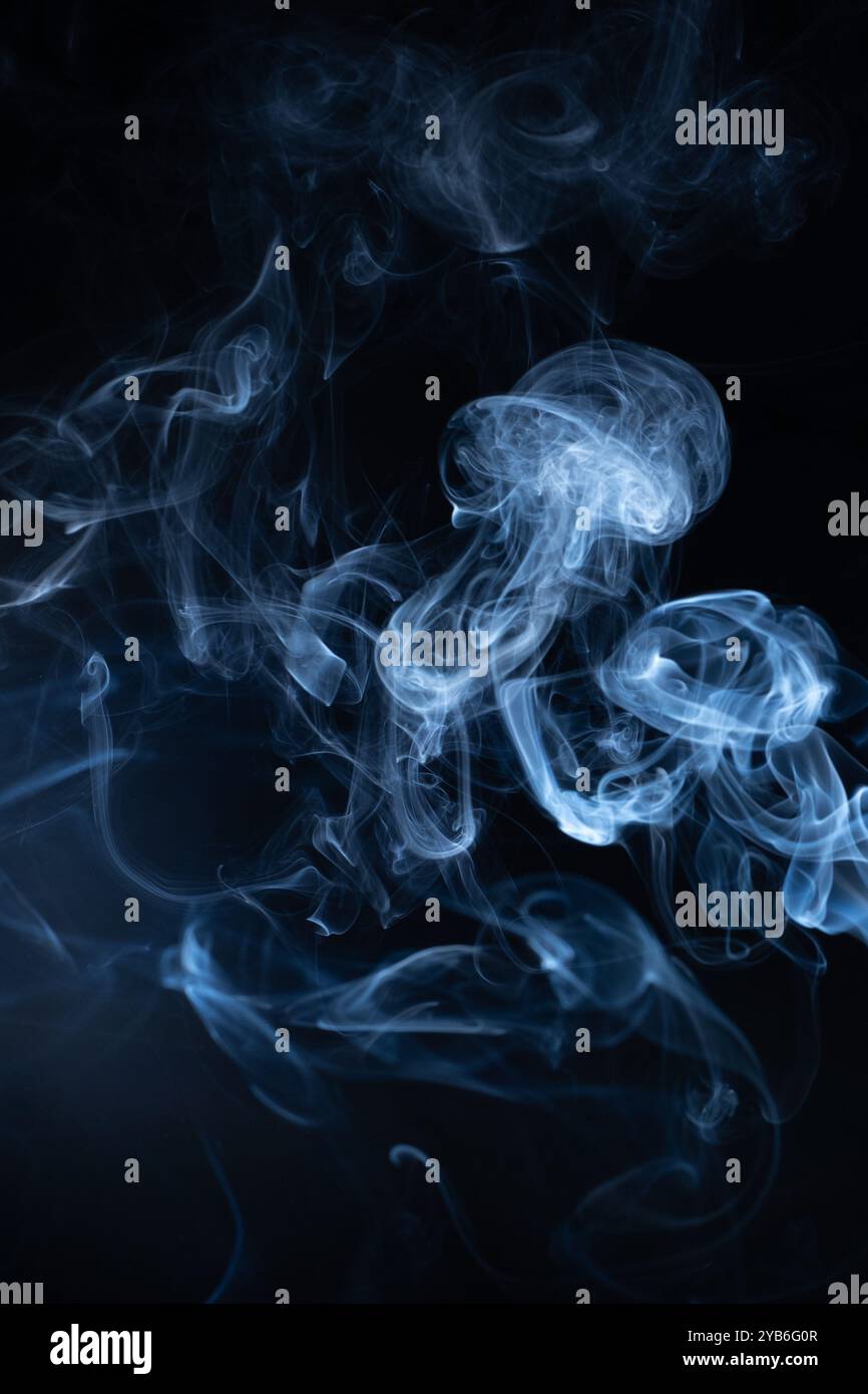 Blue smoke rising from darkness creating abstract shapes Stock Photo ...