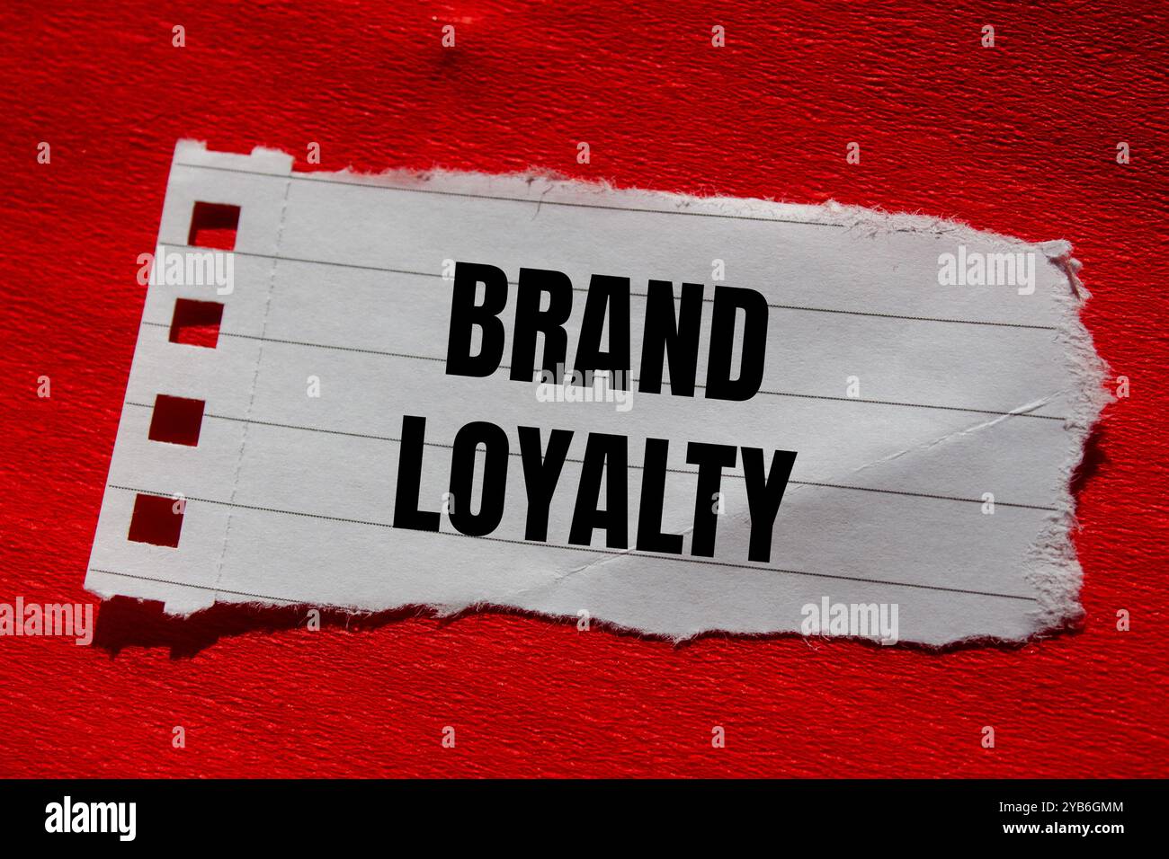Brand loyalty message written on ripped torn paper piece with red ...