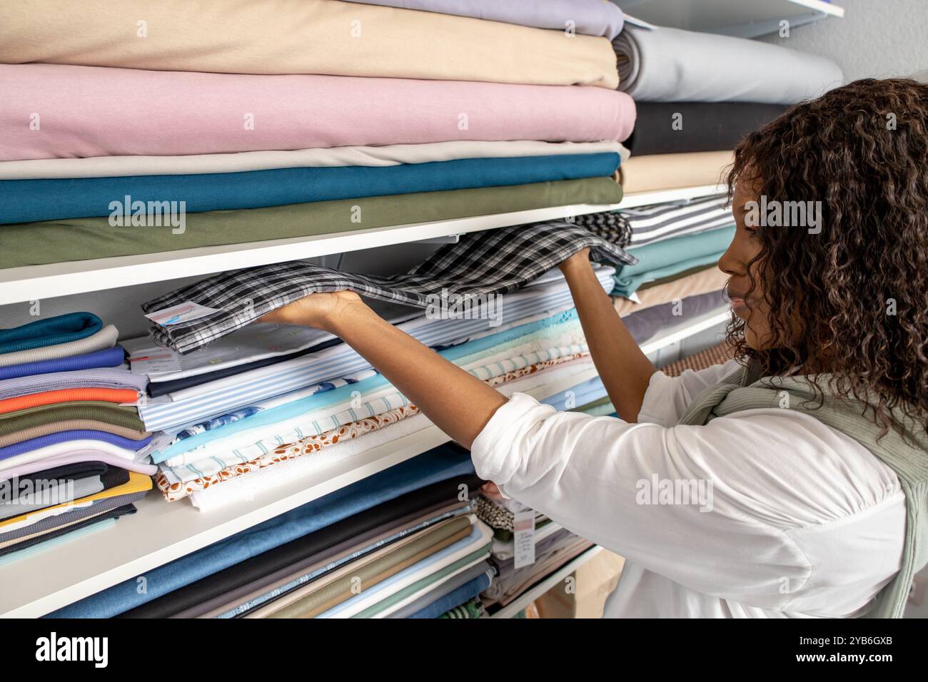 Female designer choosing fabrics for clothing in boutique Stock Photo ...