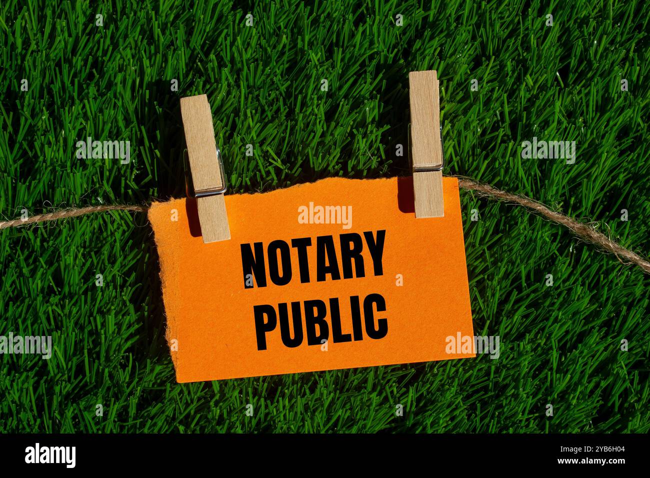 Notary public message written on ripped torn orange paper piece with ...