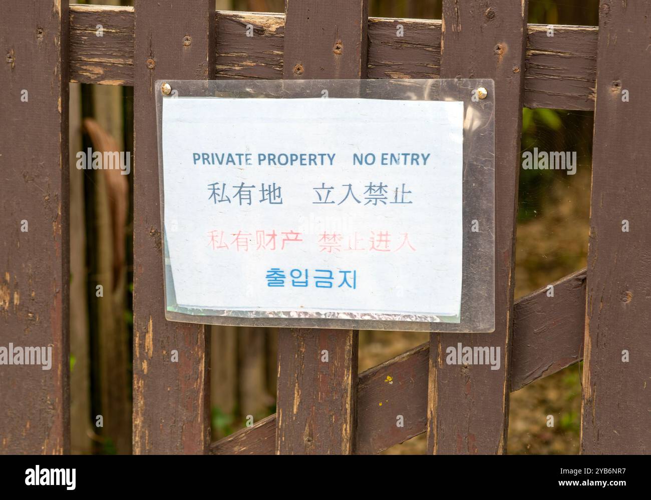 Private Property, No Entry sign on gate written in English and Asian ...
