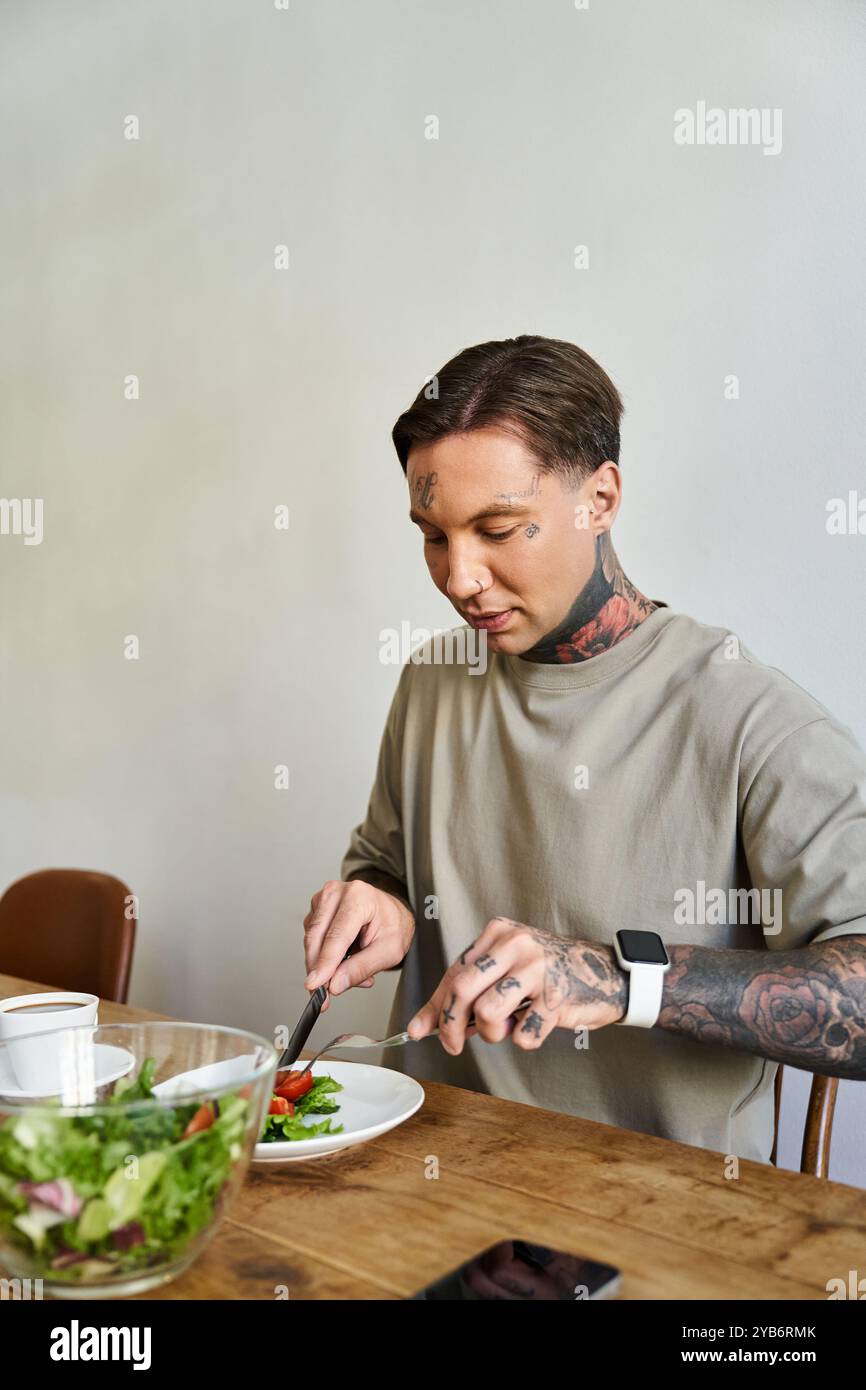 A handsome young man focuses on his nutritious meal at home, savoring ...