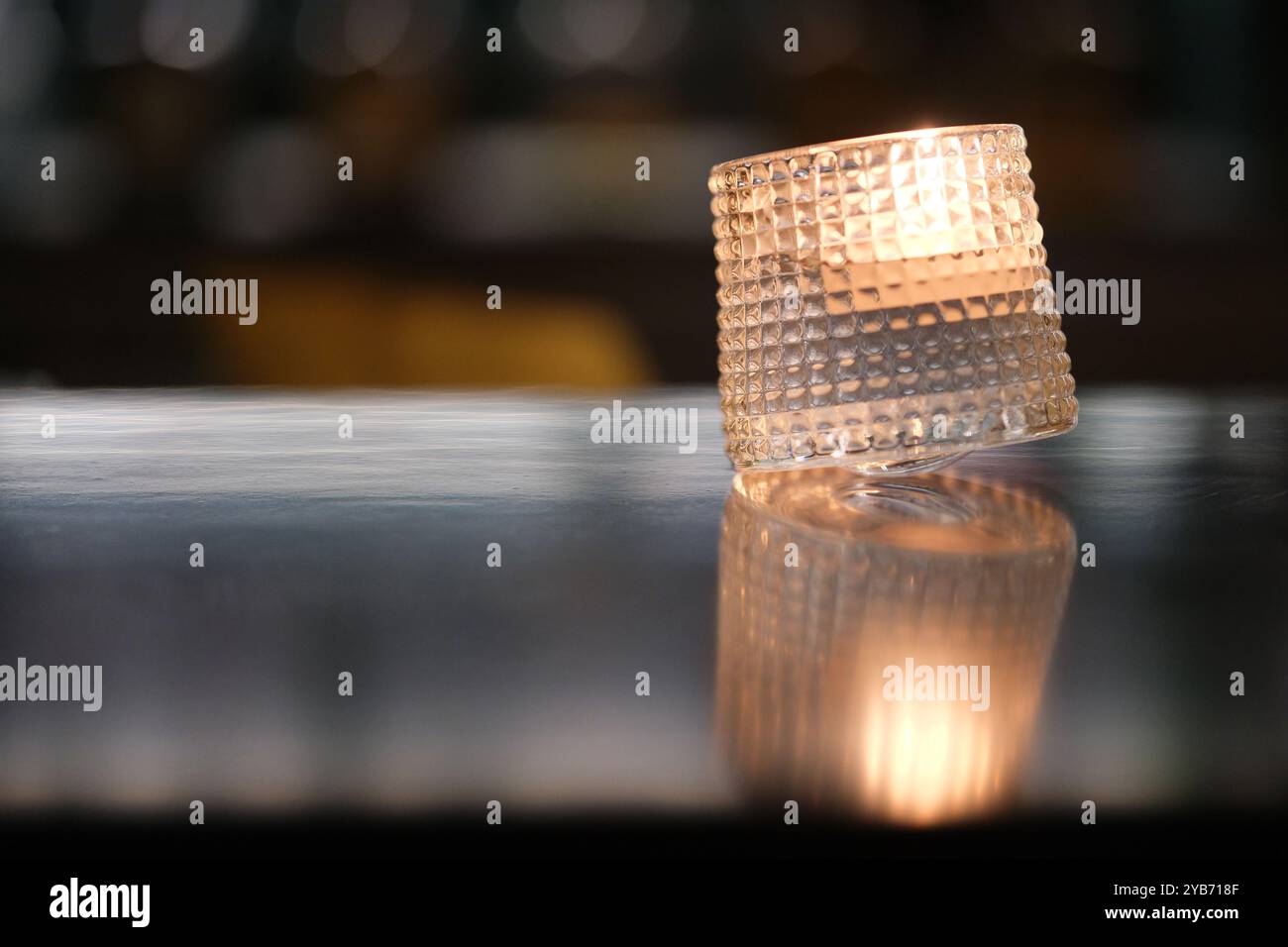 close up candle light in glass on bar counter with defocus bokeh at ...