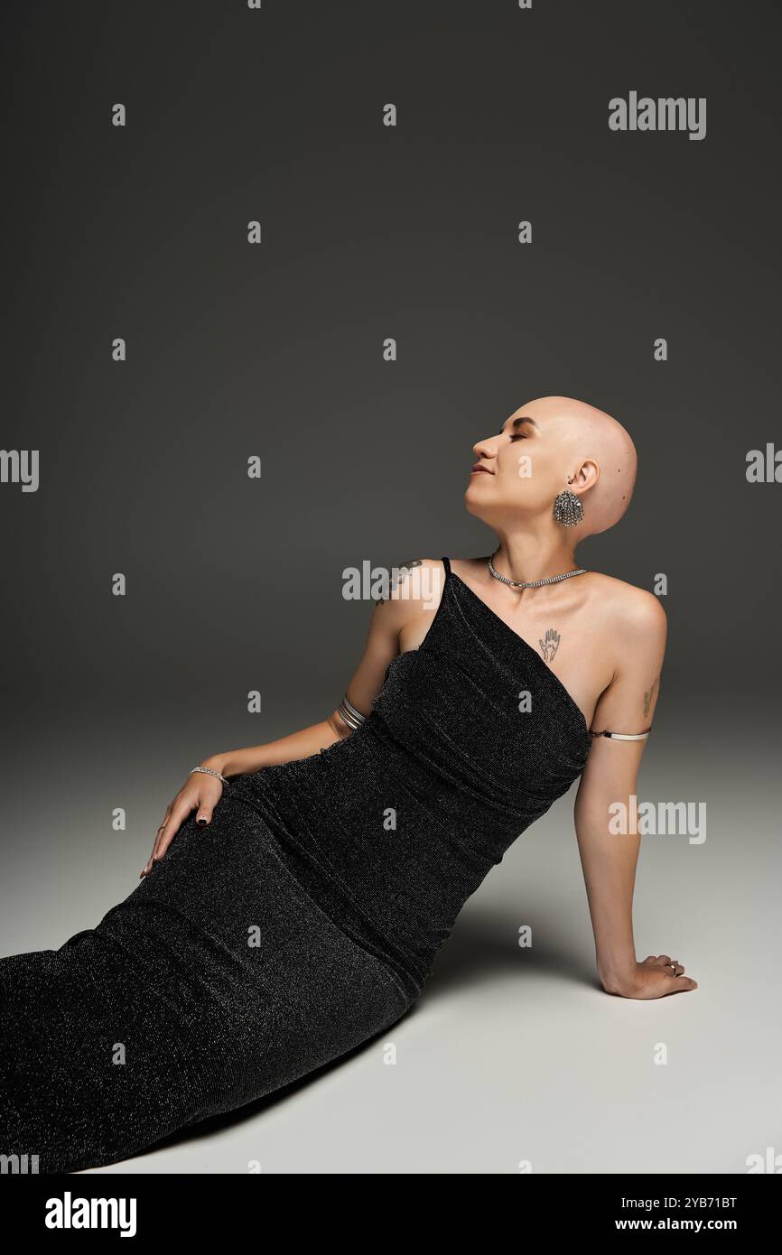 A young bald woman with alopecia elegantly poses in a stylish black ...