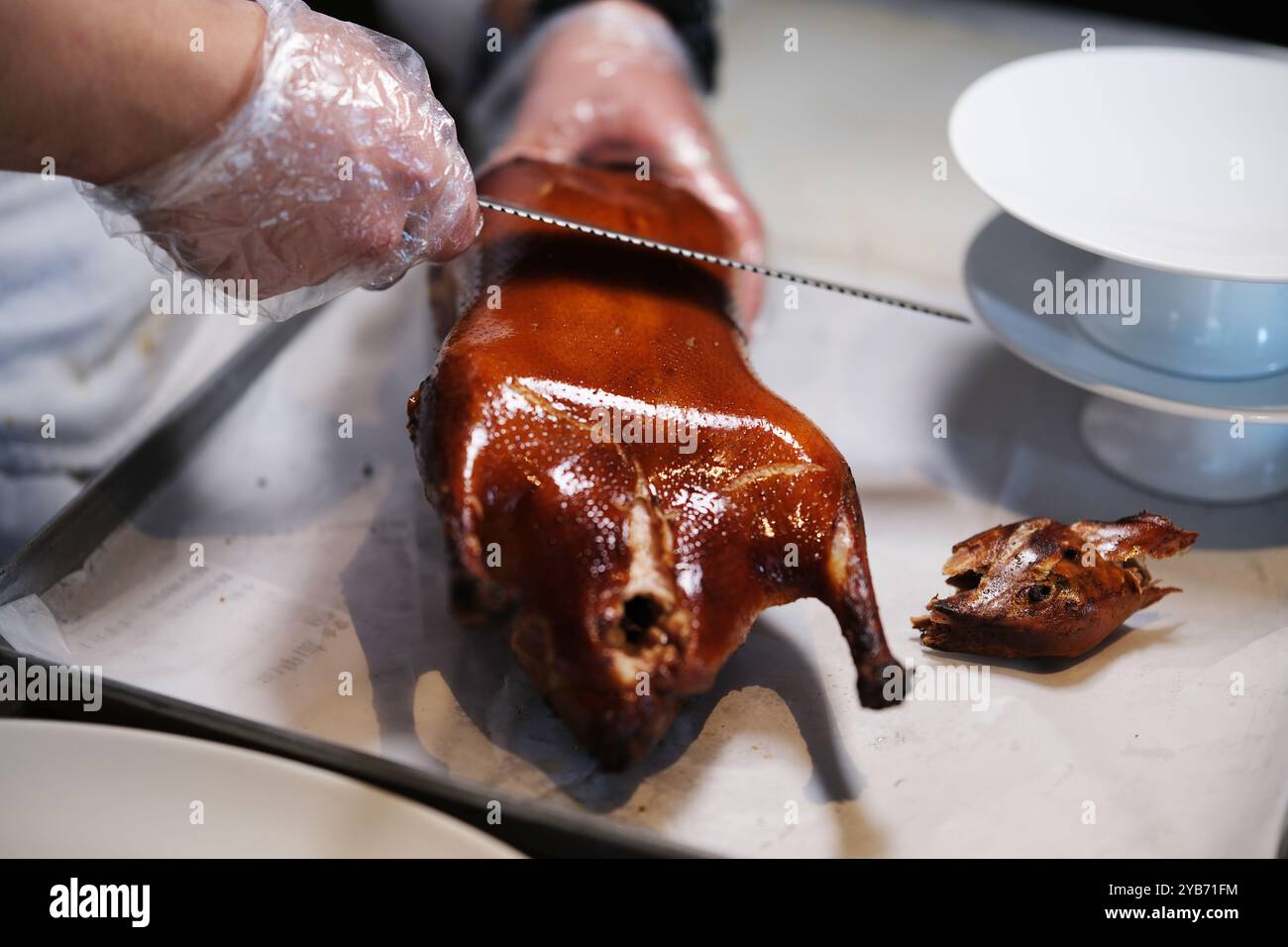 cooking Peking duck. Chef's hand slicing roasted Peking duck ...
