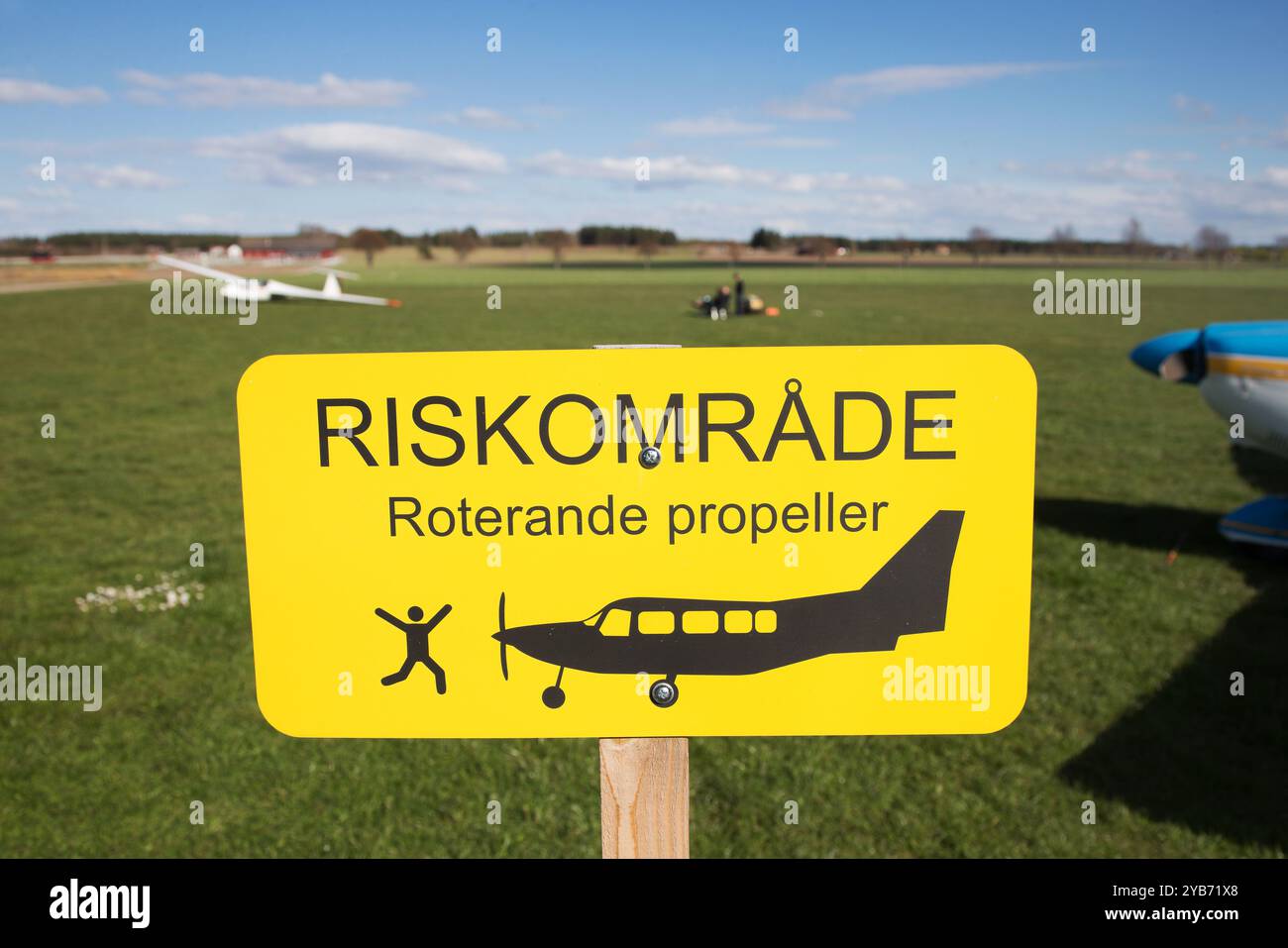 A glider is drawn up with a propeller plane on an airfield. In the ...