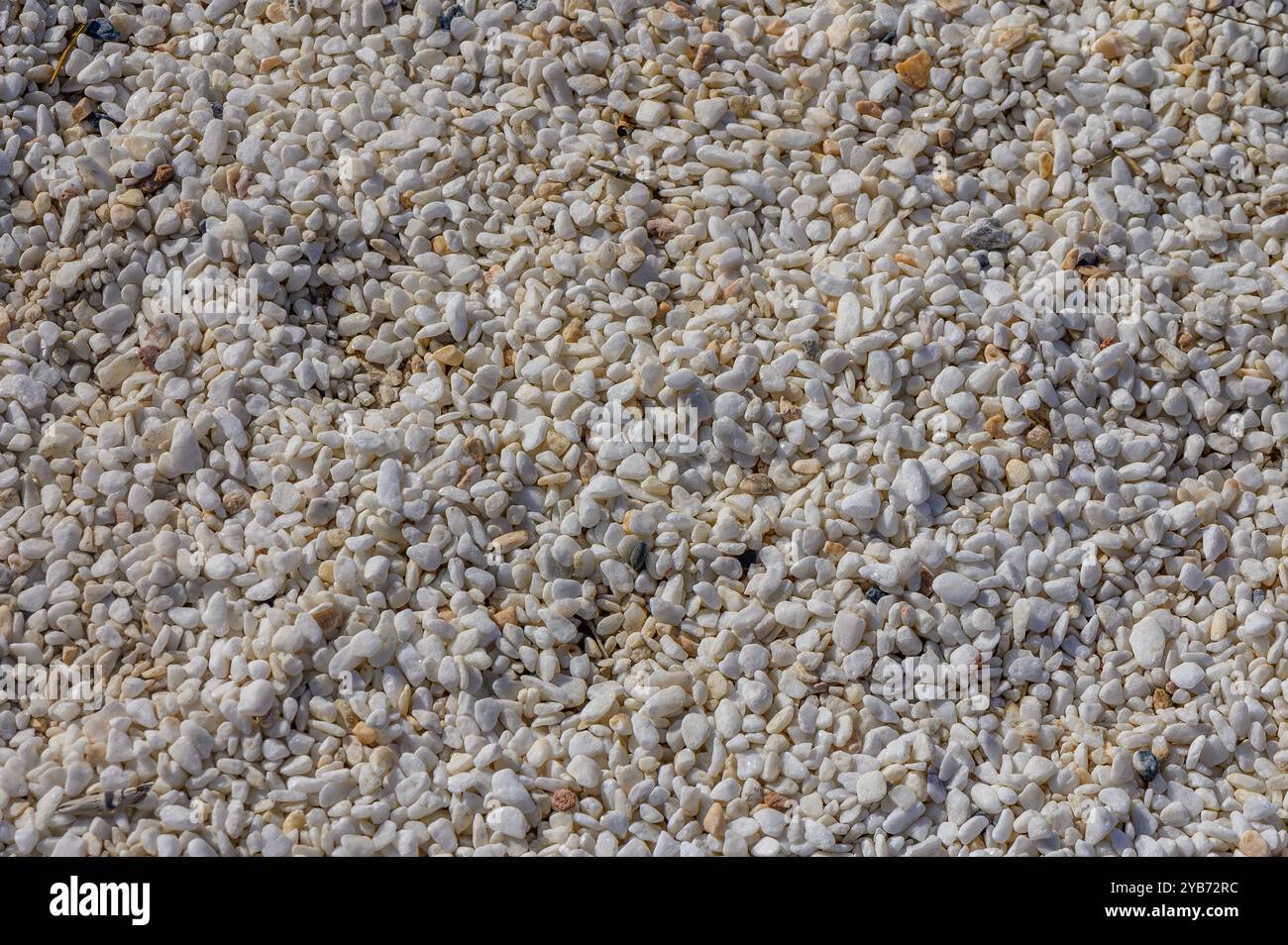 A serene expanse of smooth, white pebbles lies beneath a bright blue ...