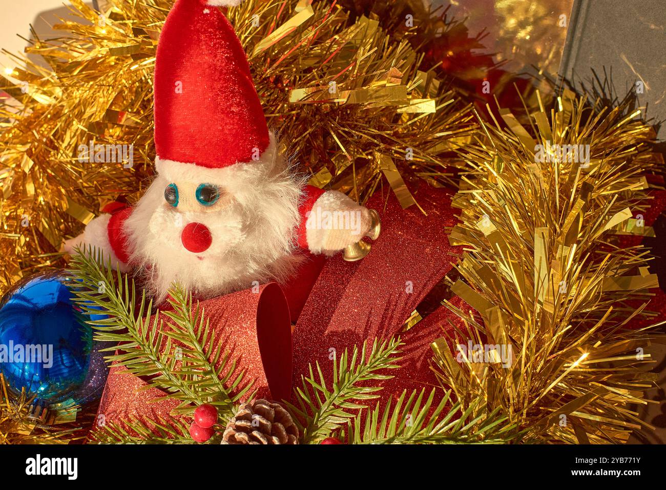 Santa Claus plush toy sitting amidst a festive Christmas scene. The ...