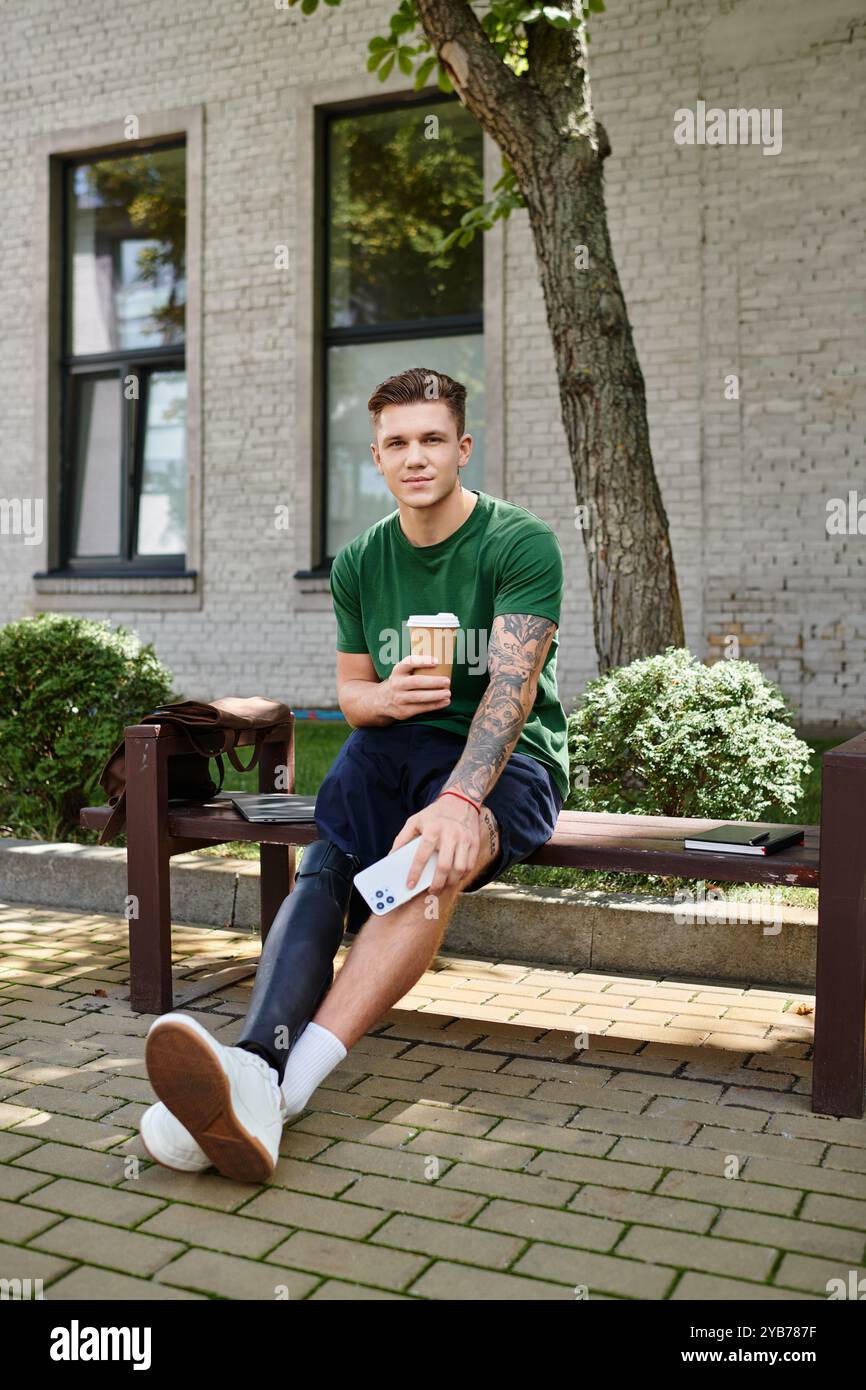 A young man with a prosthetic leg relaxes on a bench, sipping coffee in ...