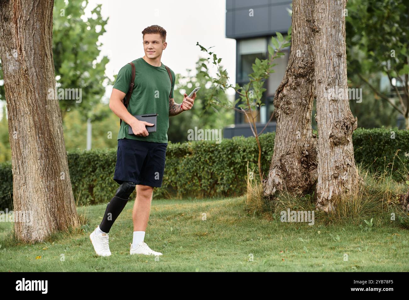A young man with a prosthetic leg strolls through a lush park ...