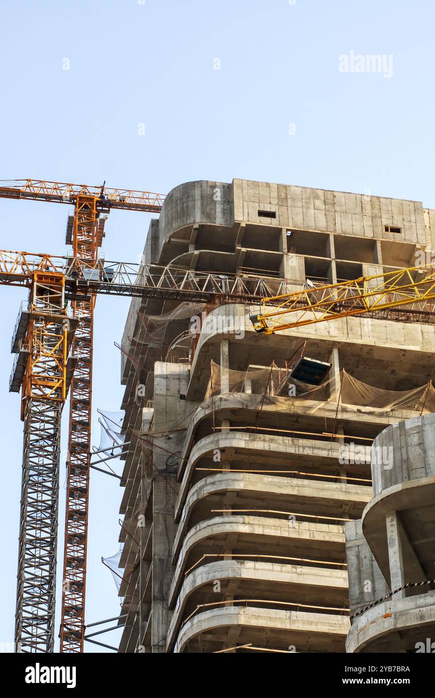 A bustling construction site featuring several cranes in action, and a ...