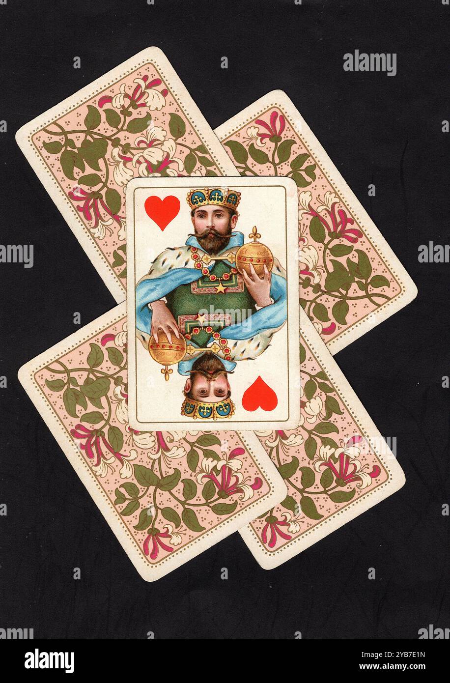 A montage of playing cards with one card revealed on a black background ...