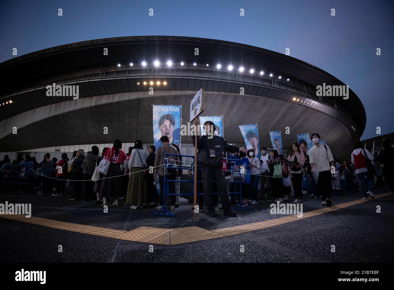 People wait in line to enter the Tokyo Metropolitan Gymnasium to attend ...