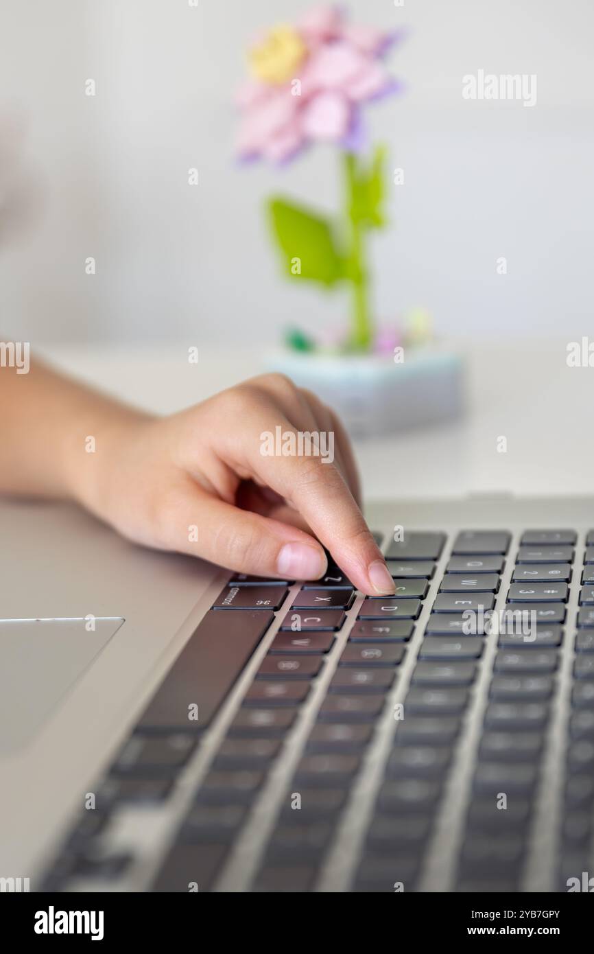 The girl is typing on the laptop keyboard. Girl's hands on the keyboard ...