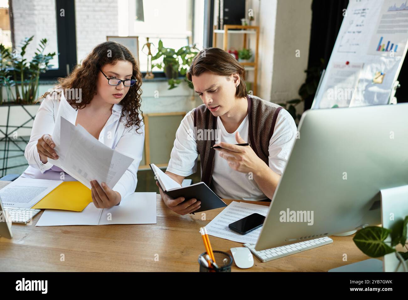 A young plus size woman and her male friend discuss ideas at a modern ...