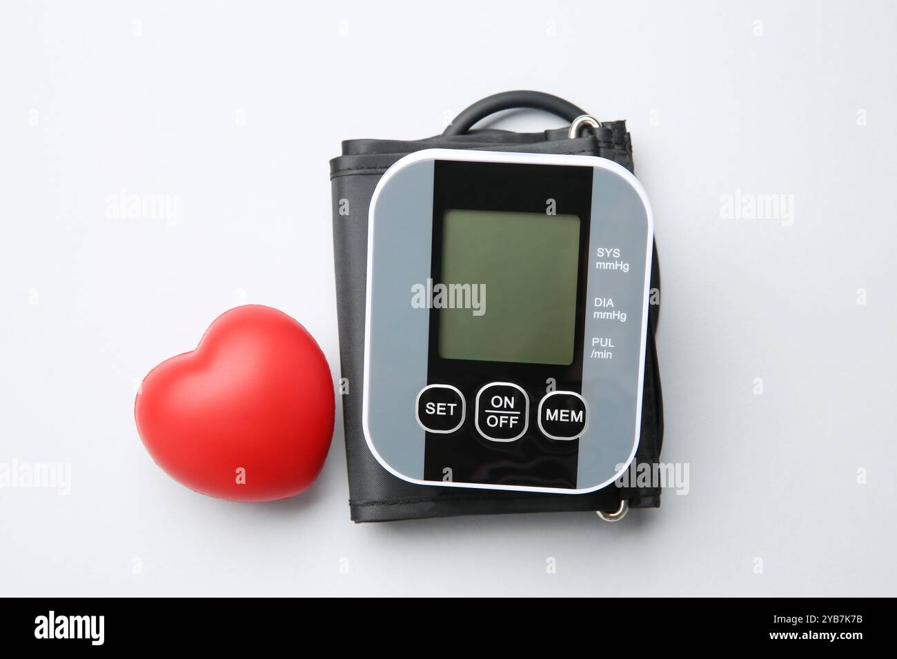 Blood pressure measuring device and squeeze heart on white background ...