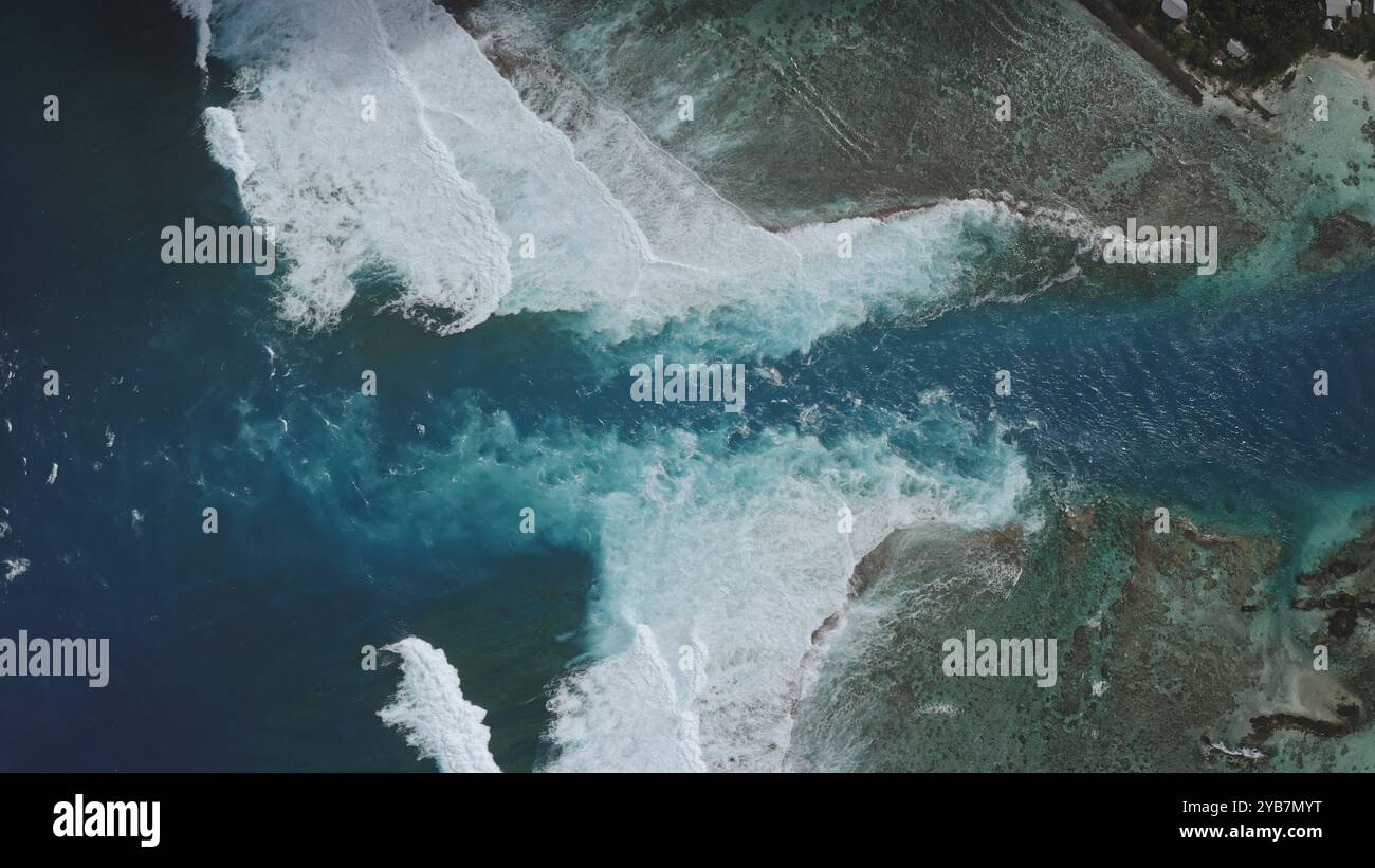 Aerial view of powerful ocean waves crashing on the coral reef barrier ...