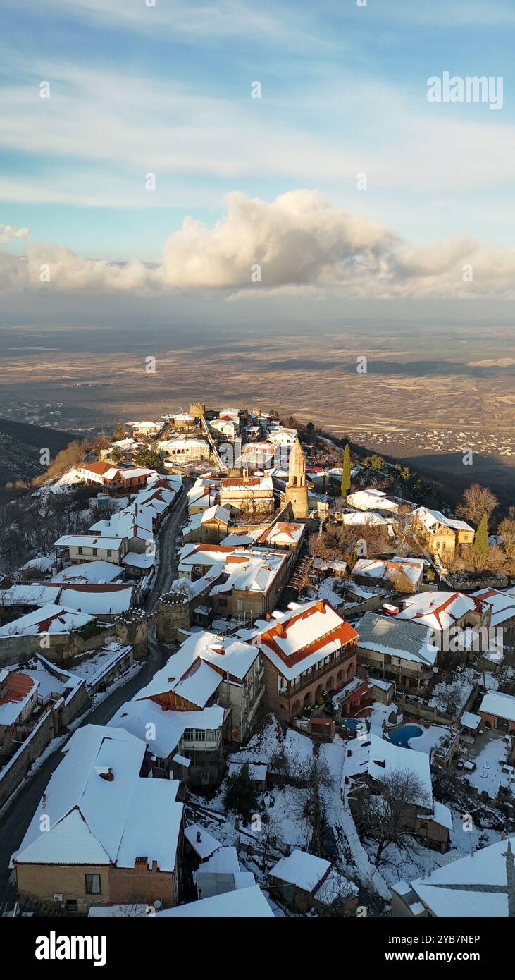 A breathtaking aerial view of a snow-covered hilltop village in Georgia ...