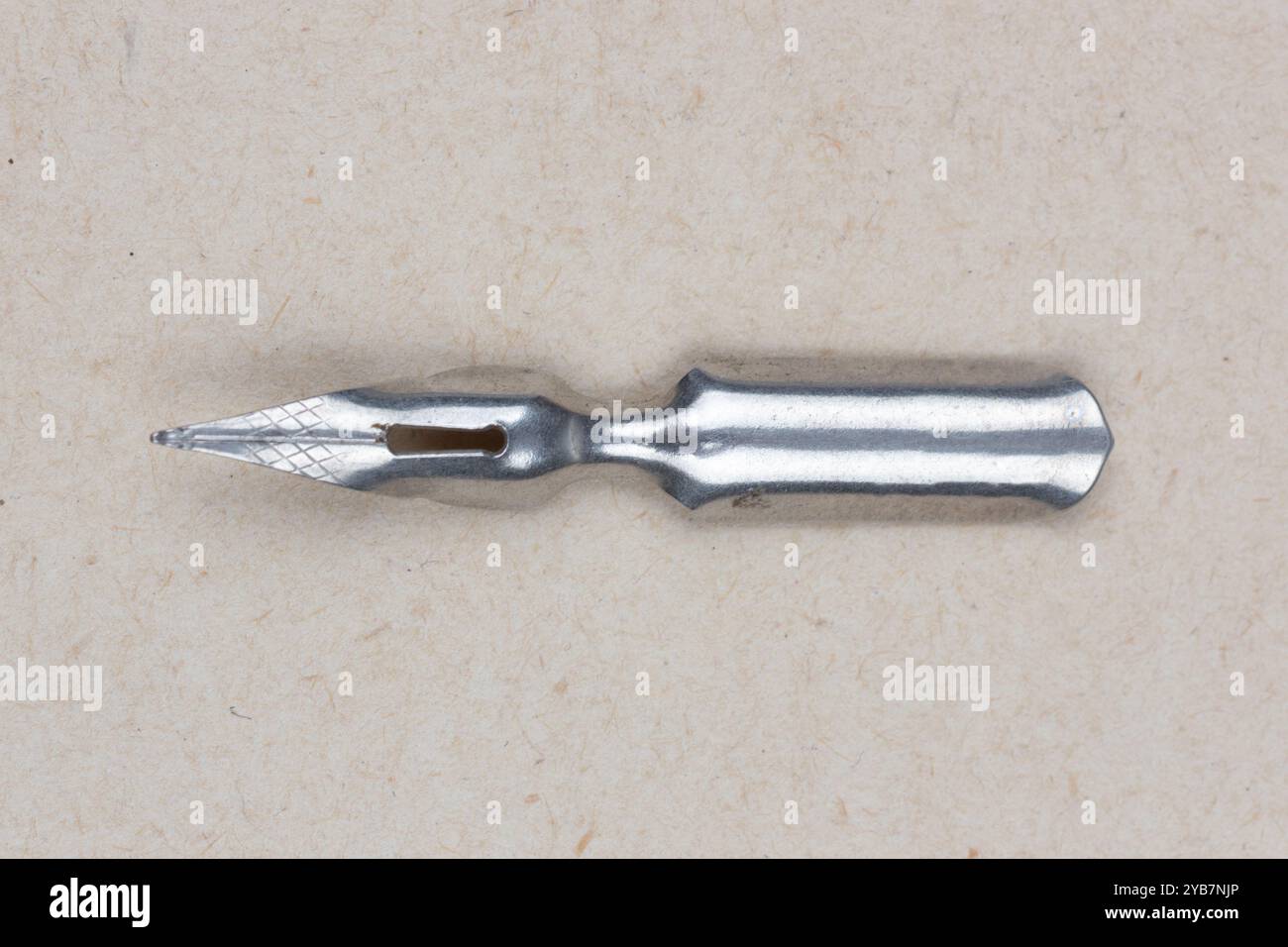 Metal nib on an antique textured paper background Stock Photo - Alamy