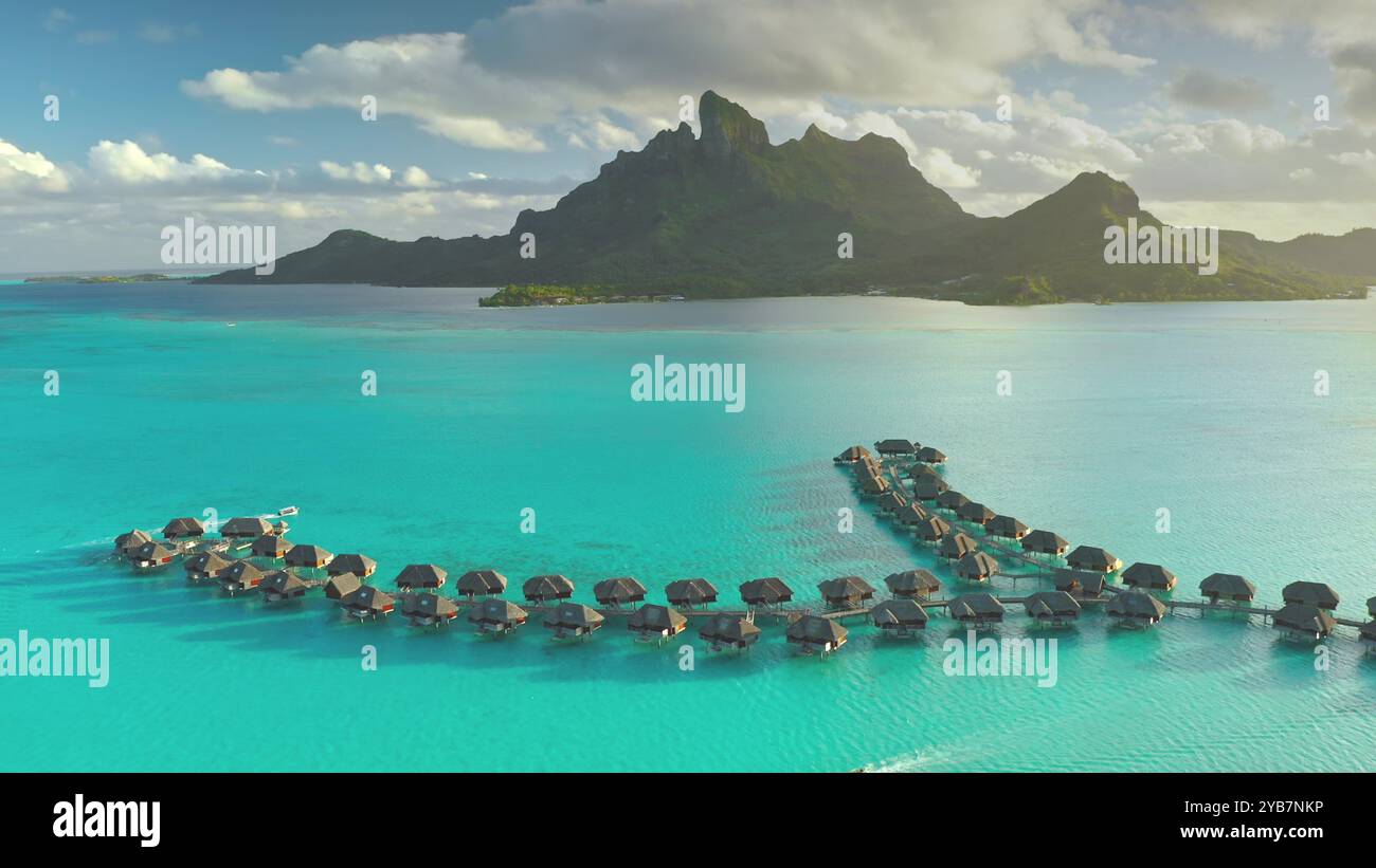 Overwater bungalows resort lining up turquoise blue lagoon of Bora Bora ...