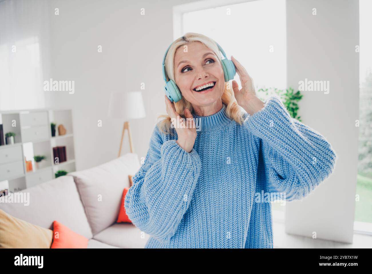 Photo of pretty aged woman arms touch headphones wear pullover free ...