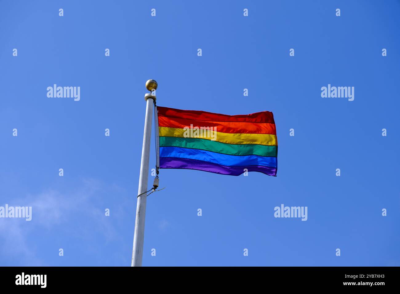 Rainbow flag in blue sky. Pride flag. Symbol of LGBT pride Stock Photo ...