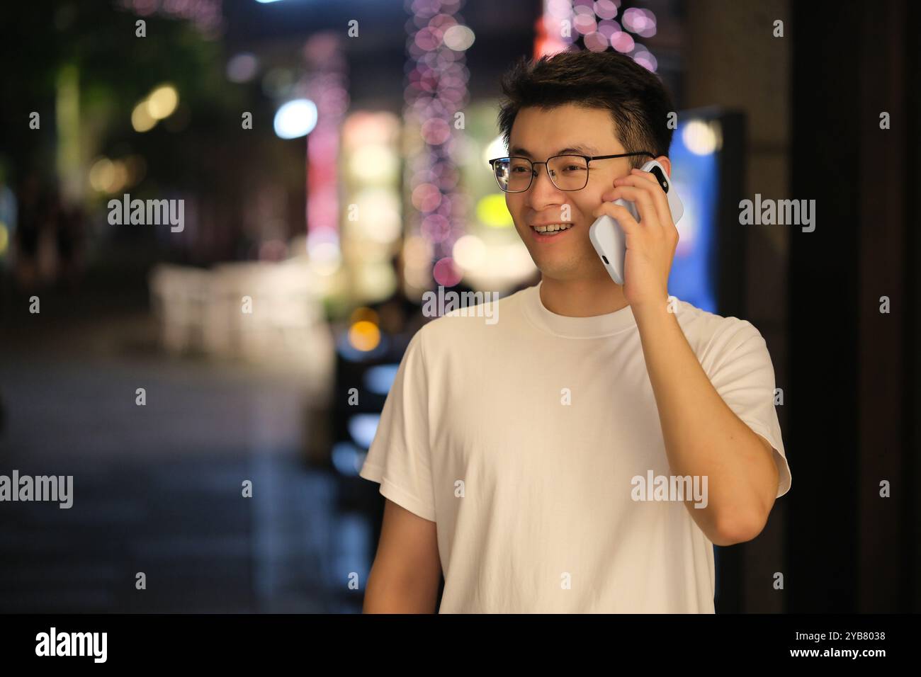 Asian young man make phone call outdoor at night Stock Photo - Alamy