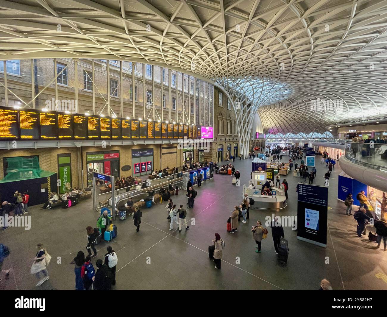 kings cross station booking hall with travellers, departure board ...