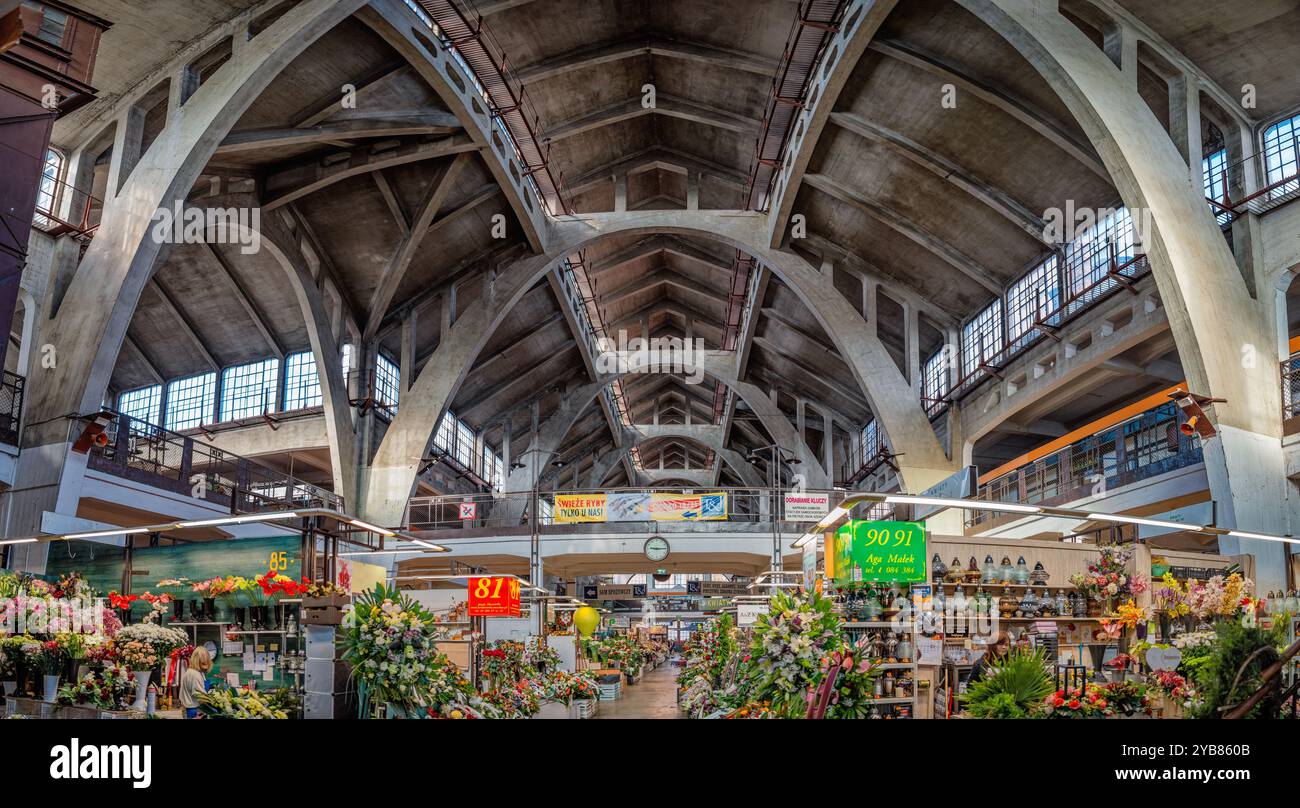 A bustling indoor market with high ceilings, showcasing vibrant stalls ...
