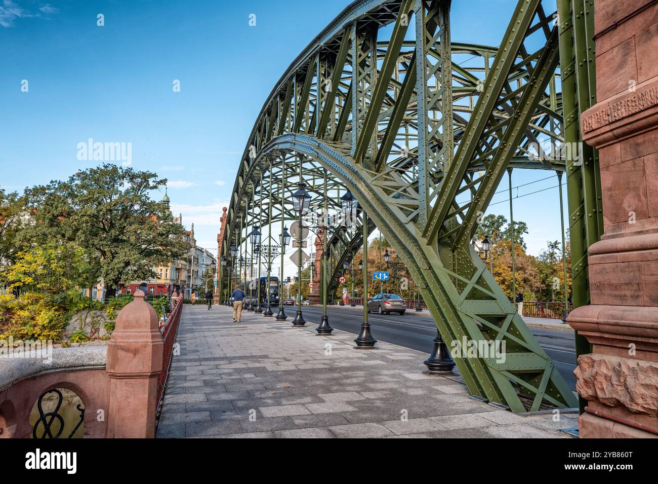 A historic steel arch bridge with intricate stone pillars under a clear ...