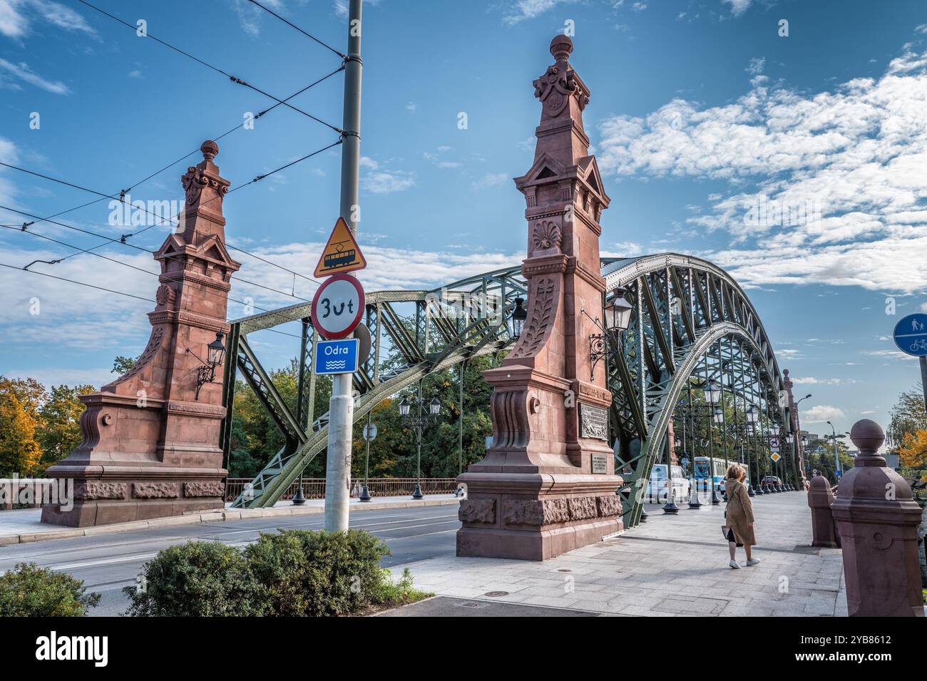 A historic steel arch bridge with intricate stone pillars under a clear ...