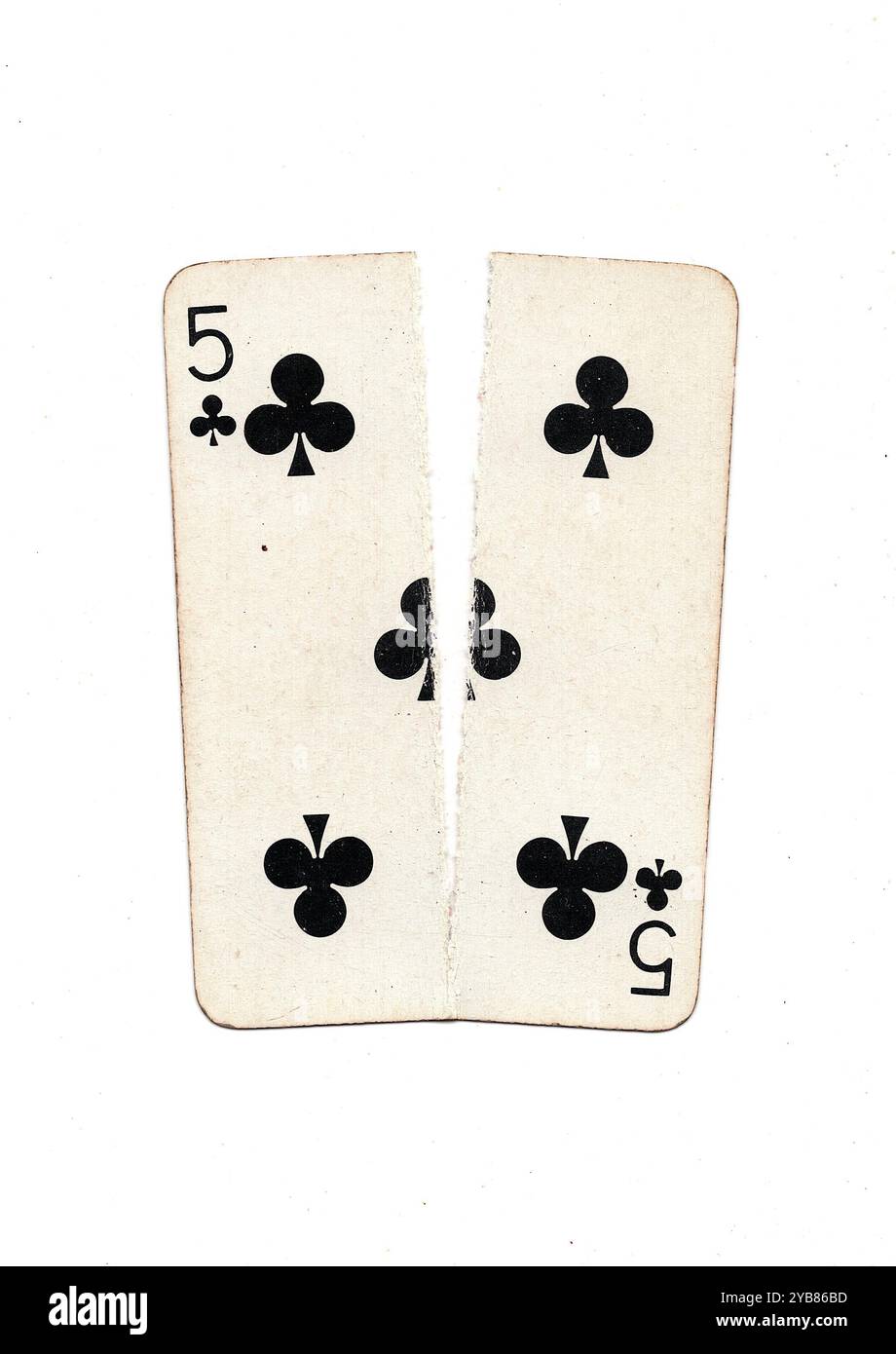 A vintage playing card torn in half from top to bottom on a white ...