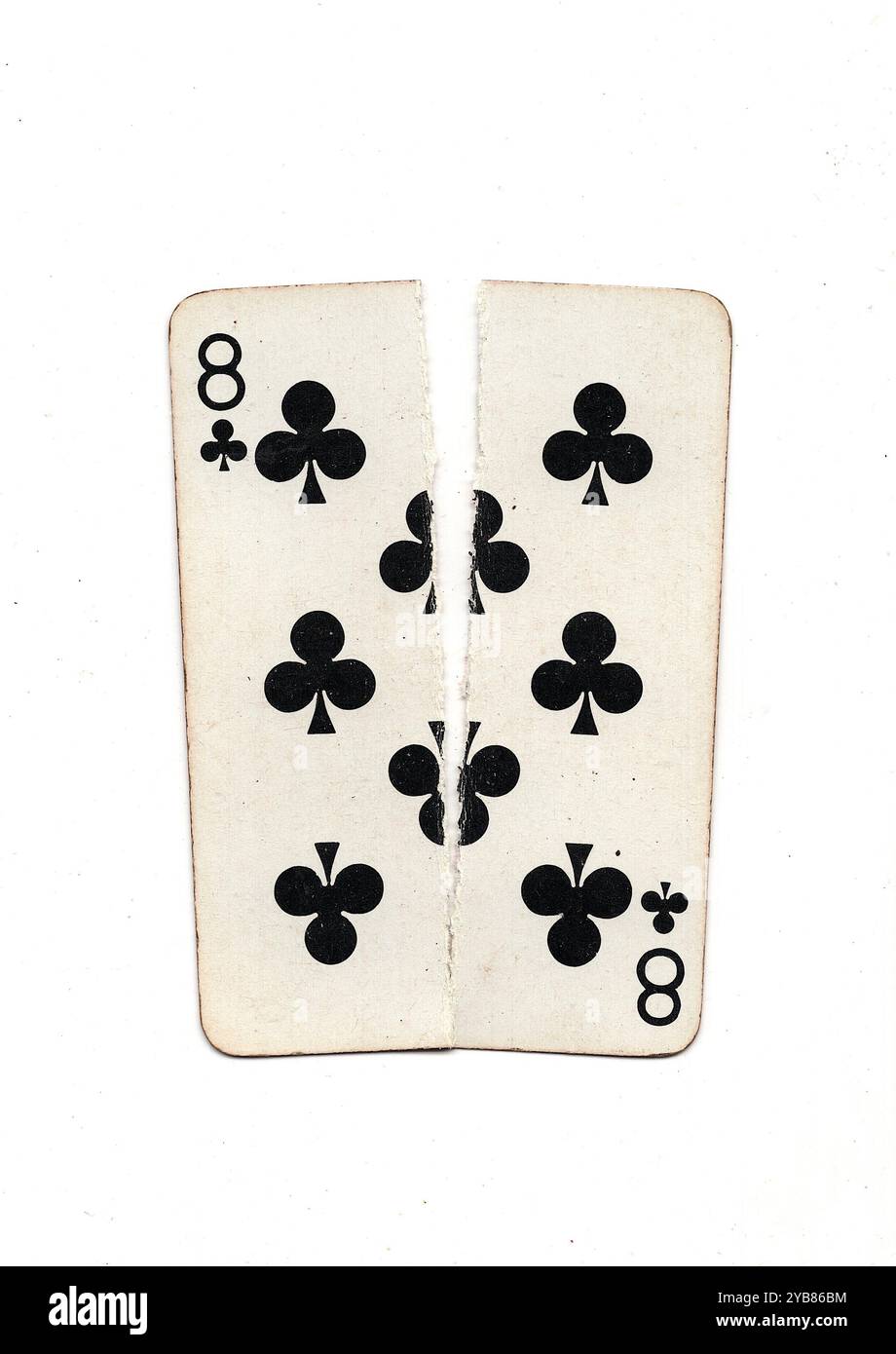 A vintage playing card torn in half from top to bottom on a white ...