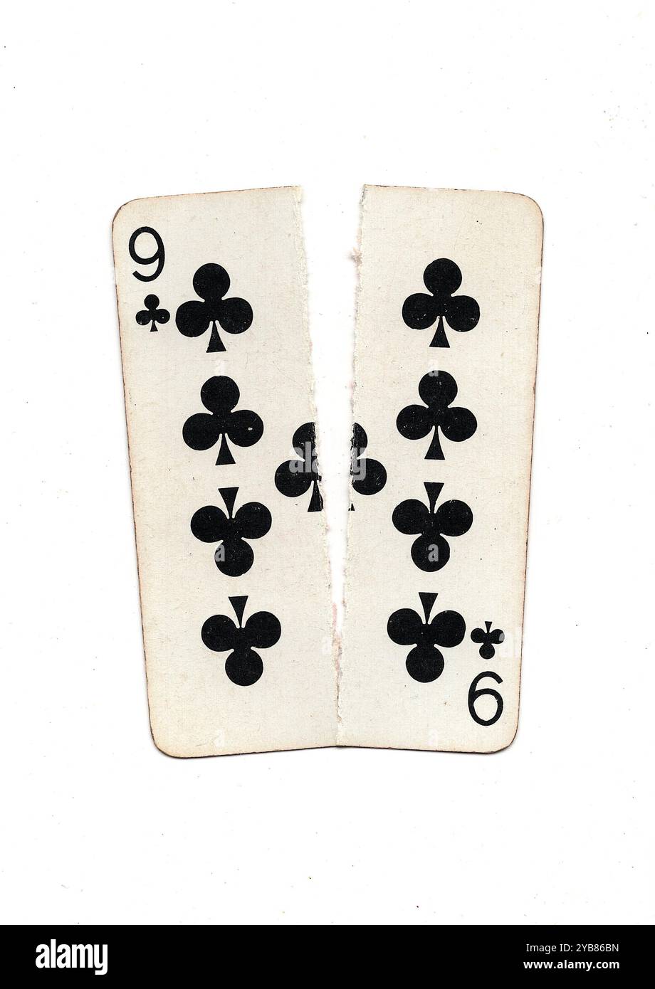 A vintage playing card torn in half from top to bottom on a white ...